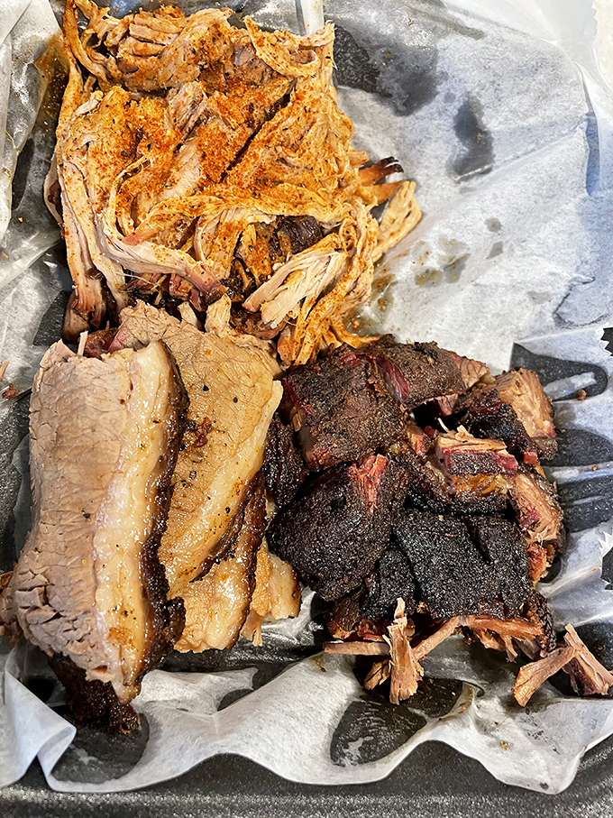Behold the holy trinity of BBQ: pulled pork, brisket, and burnt ends creating a masterpiece worthy of a standing ovation.
