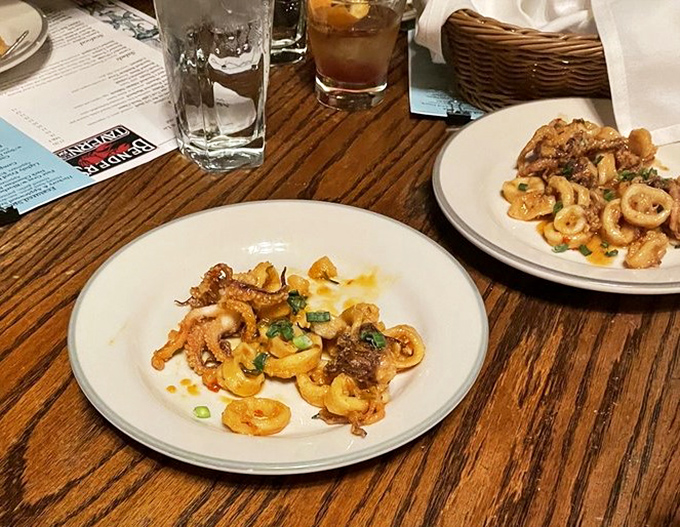 This calamari isn't just fried &ndash; it's transformed into golden morsels of oceanic delight, scattered with bright herbs that make each bite a tiny celebration.