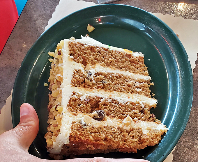 Behold the legendary carrot cake in all its multi-layered glory—each stratum of spiced perfection separated by cream cheese frosting that dreams are made of.
