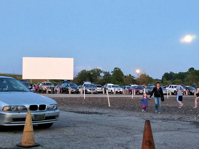 The anticipation builds as families stroll between parked cars at twilight. That magical moment when day surrenders to night and the screen comes alive.