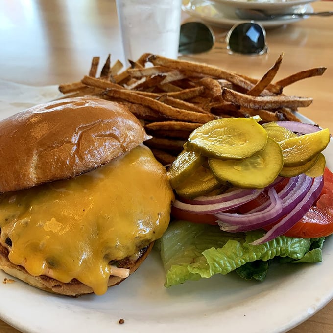 Behold the star attraction: a perfectly melted cheeseburger with all the fixings and crispy sweet potato fries that could make a French chef weep.