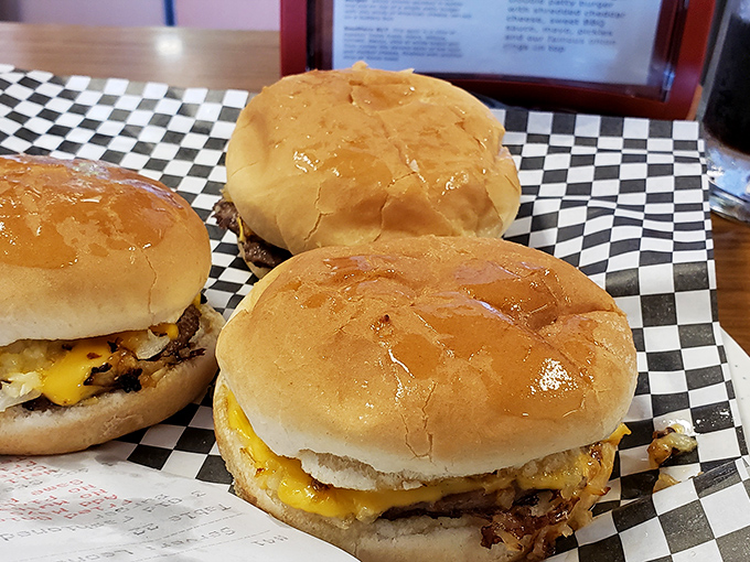 Three perfect cheeseburgers on their classic checkered paper&mdash;like a chess match where your taste buds always win, no matter which one you choose.