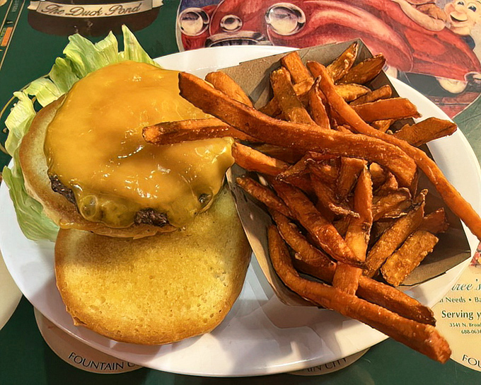 This isn't just a cheeseburger; it's a masterpiece of melty perfection on a house-baked bun with sweet potato fries that deserve their own fan club.