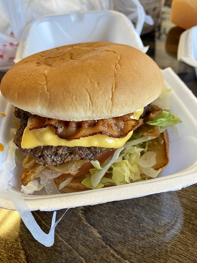 Behold burger perfection: melty American cheese cascading down a hand-formed patty, nestled in a perfectly toasted bun. Poetry on a plate.