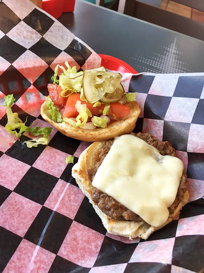 Behold the architecture of perfection: a hand-formed patty, melted cheese cascading like a yellow waterfall, and toppings arranged with more care than some wedding seating charts.