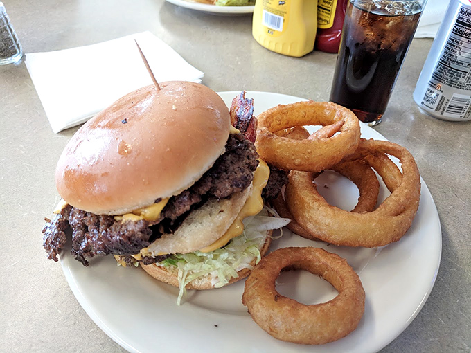 The star of the show: a perfectly smashed burger with those signature crispy edges that extend beyond the bun like a delicious halo of happiness..