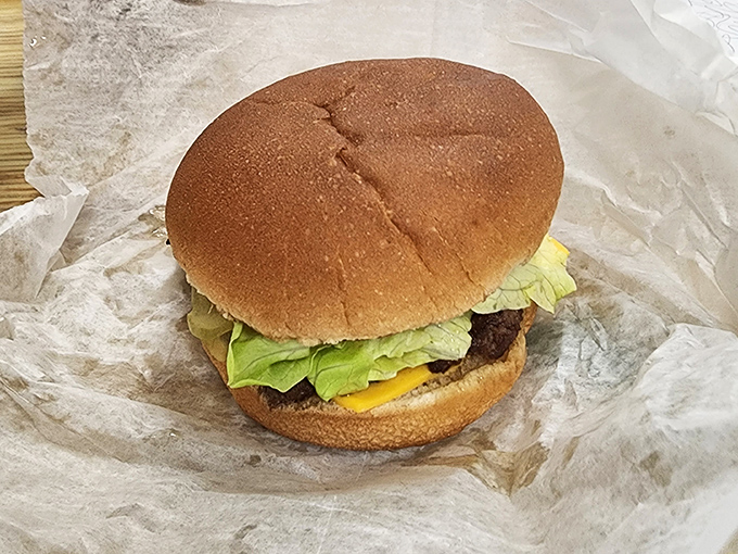 Behold the classic cheeseburger in its natural habitat: wrapped in paper, glistening with promise, ready to change your day.