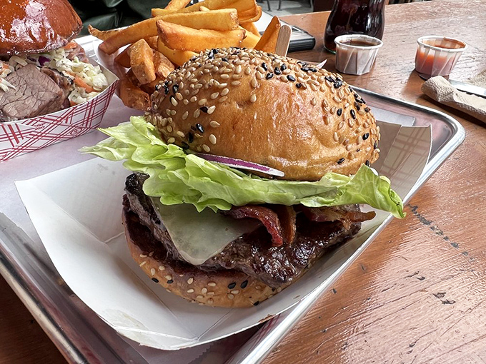Behold the cheeseburger that launched a thousand food pilgrimages. That sesame-studded bun isn't just holding a patty—it's cradling a masterpiece of beef architecture.