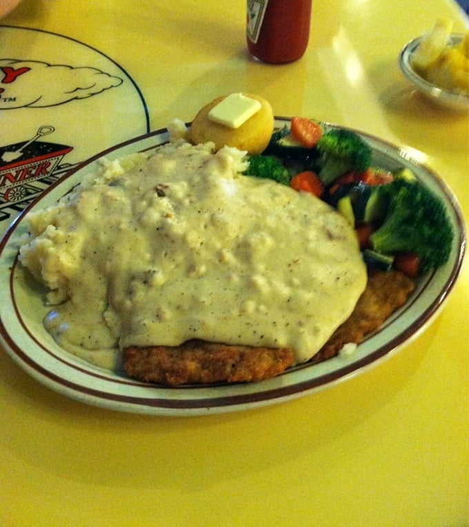 Behold the star of our show: chicken fried steak swimming in gravy with a side of veggies pretending to make it healthy. This plate has comforted more souls than a therapist.