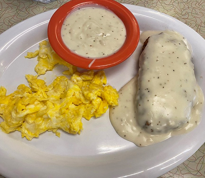 Behold the holy trinity of Southern breakfast: chicken fried steak smothered in pepper gravy, scrambled eggs, and a side of pure joy.