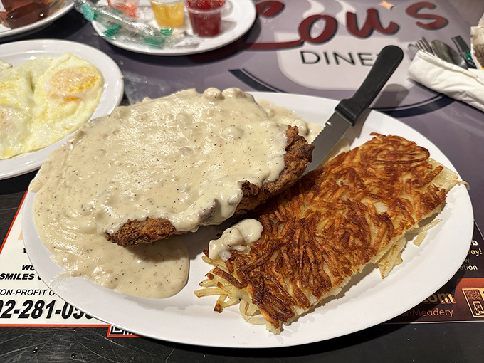 Behold the crown jewel: chicken fried steak swimming in peppery country gravy alongside golden hash browns that achieve the perfect crisp-to-tender ratio.