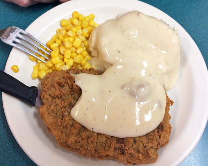 Behold the star attraction: a golden-brown chicken fried steak that practically eclipses the plate, smothered in pepper-flecked gravy that your grandmother would approve of.