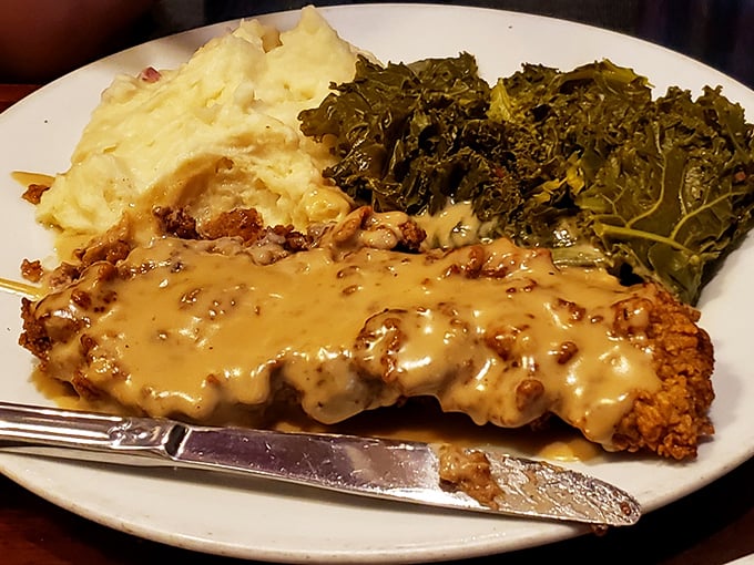 Behold the star attraction: chicken fried steak bathed in peppery gravy, flanked by creamy mashed potatoes and collard greens that mean business.