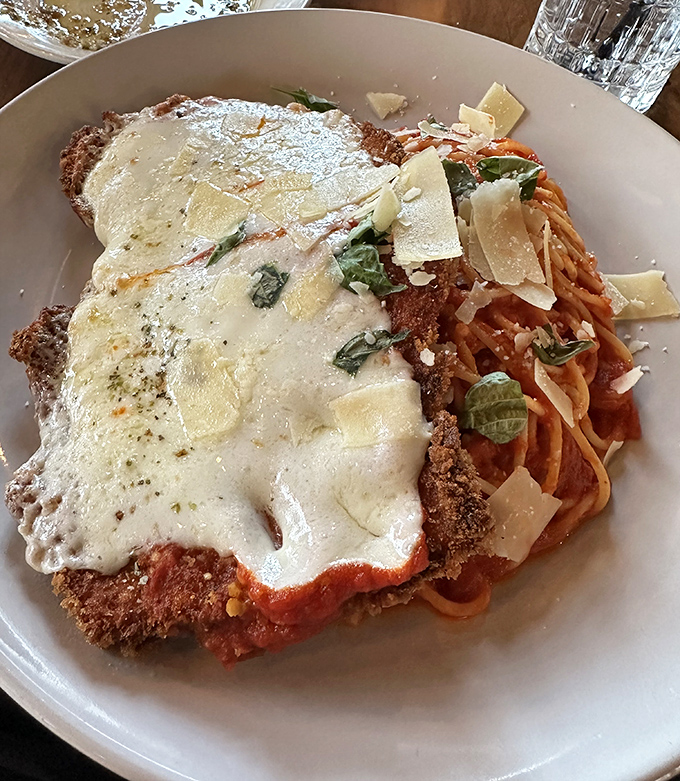 Behold the star attraction: chicken parmigiana that achieves the holy trinity of crispy, saucy, and cheesy, with pasta that knows its supporting role perfectly.