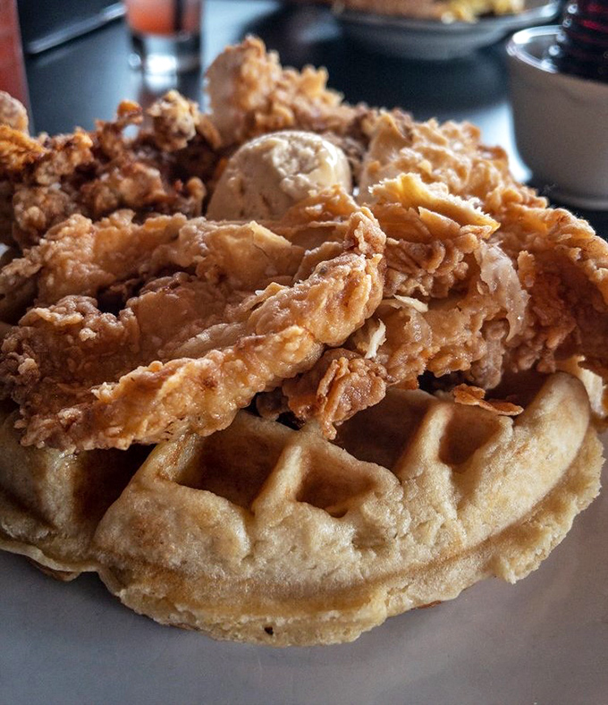 Behold the main event: crispy fried chicken embracing a golden waffle like old friends at a reunion.