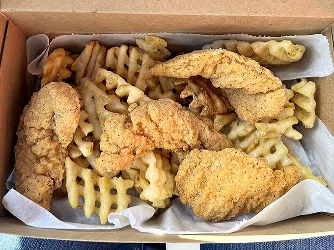 Golden-brown chicken fingers that could make Colonel Sanders weep with jealousy, nestled alongside perfectly crisp waffle fries&mdash;a match made in comfort food heaven.