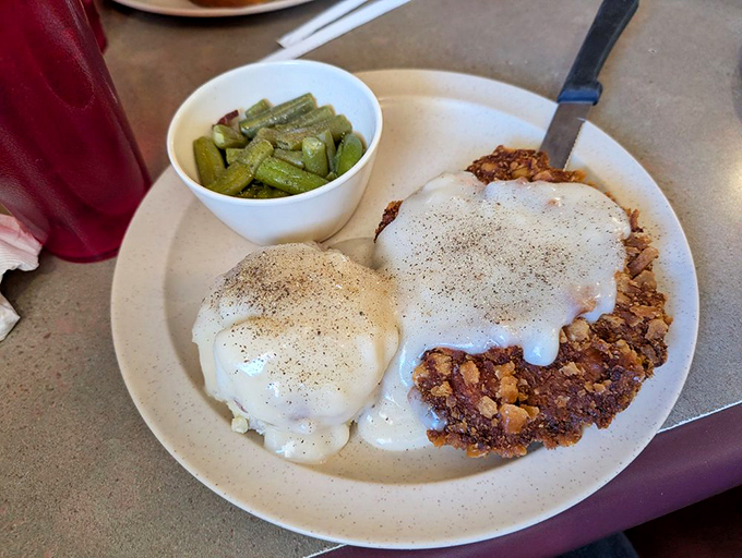 Behold the star attraction: chicken fried steak smothered in peppery gravy with a side of green beans&mdash;a plate that whispers "Nebraska" with every bite.
