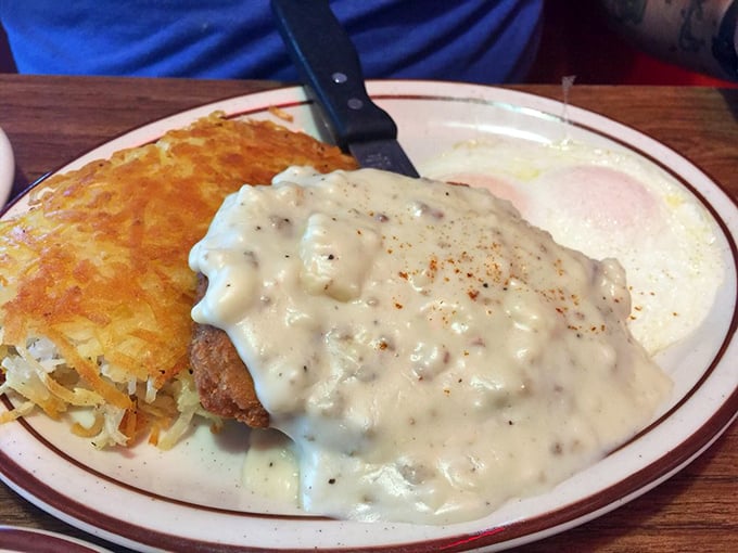 Behold the star attraction: chicken fried steak smothered in country gravy alongside golden hashbrowns and eggs—a plate that's worth setting your alarm for.