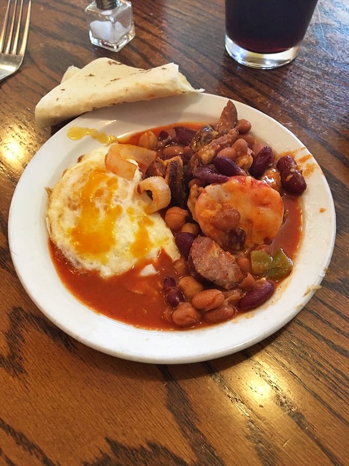 A sunny-side-up egg crowns this hearty bowl like a delicious sun rising over a landscape of beans, sausage, and savory sauce. Comfort food that hugs you from the inside.
