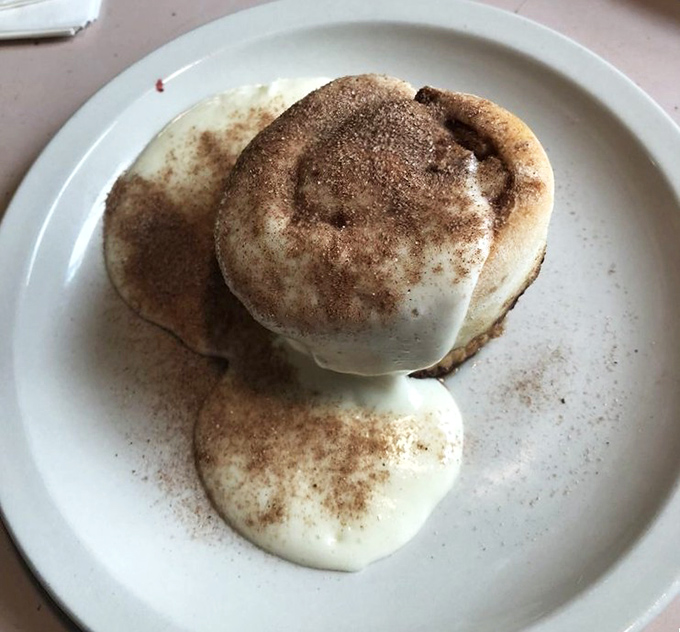 This isn't just a cinnamon roll; it's edible architecture. The icing cascades like a sugary waterfall, creating pools of sweetness that beg for your spoon.