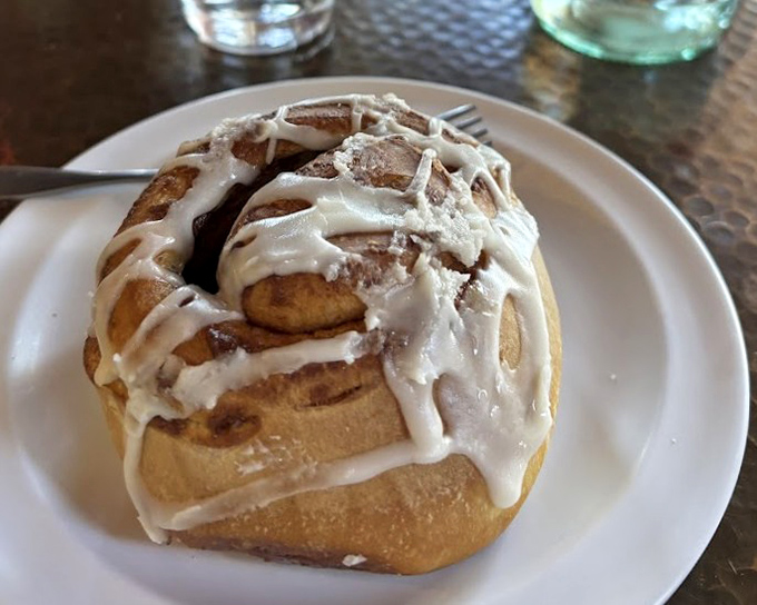 This isn't just a cinnamon roll; it's an architectural masterpiece of dough, cinnamon, and cream cheese frosting that demands a moment of respectful silence.