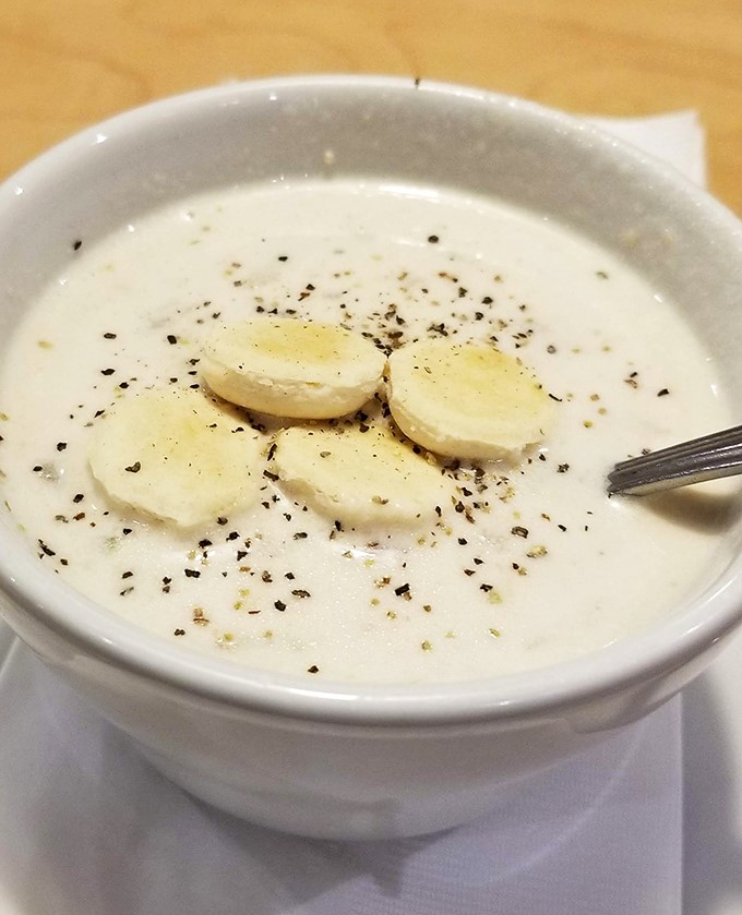 The legendary clam chowder arrives like a warm hug in a bowl, with tender clams playing hide and seek beneath the creamy surface.