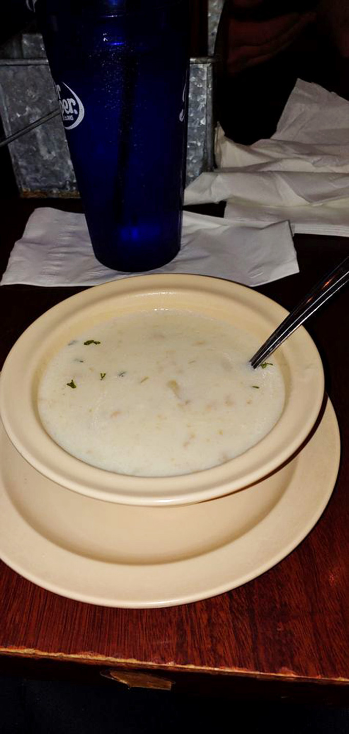 A bowl of creamy New England clam chowder that would make a Bostonian homesick, paired with an ice-cold blue tumbler of refreshment.