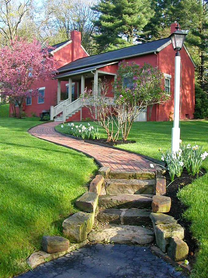 The red cottage at Clary Gardens looks like it jumped straight out of a storybook, complete with flowering trees that know exactly when to make their grand entrance.