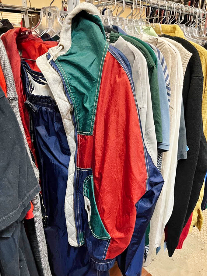 Vintage windbreakers in bold primary colors hang like wearable time capsules, each one a portal to the fashion sensibilities of decades past.