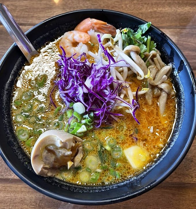 The legendary coconut curry ramen in all its glory &ndash; a sunset-colored broth cradling tender shrimp, mushrooms, and perfectly cooked noodles.