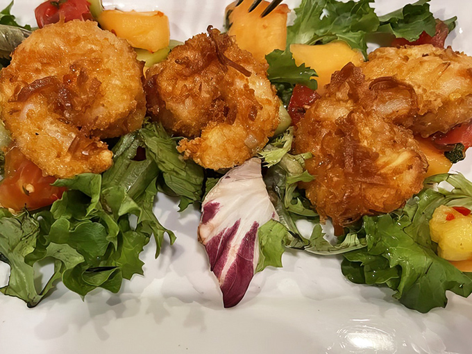 Golden-fried perfection that would make Neptune himself swim to shore. These coconut shrimp rest on a bed of greens like jewels on velvet.