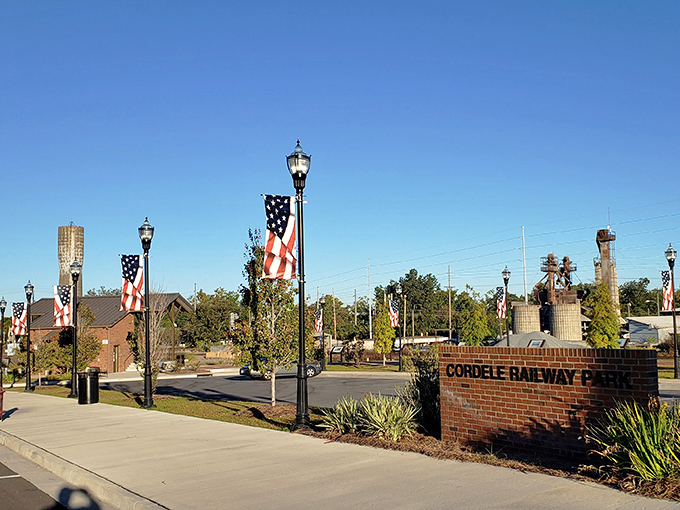 Cordele Railway Park's lamp posts stand at attention, American flags fluttering above brick pathways that invite leisurely strolls through railroad history.
