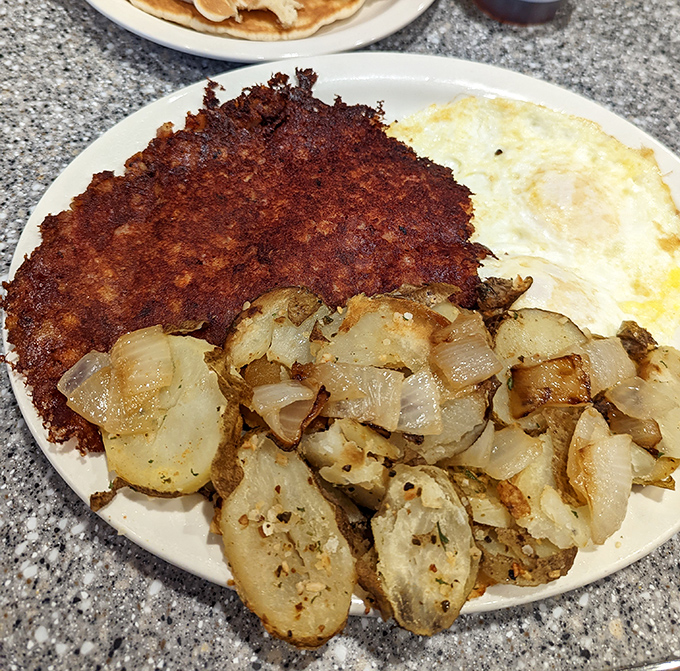 Behold the star attraction: corned beef hash with that perfect crispy-to-tender ratio, alongside golden home fries and eggs. Breakfast nirvana achieved!