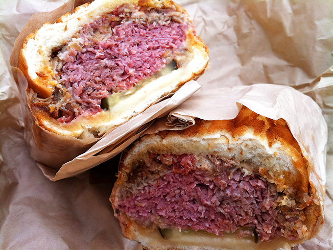 Cross-section perfection: this corned beef sandwich reveals its ruby-red heart, a testament to proper brining that would make your grandmother weep with joy.