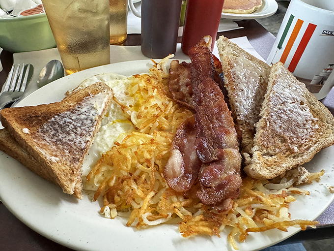 Breakfast nirvana achieved: perfectly crispy hash browns, eggs that needed no introduction, and bacon that should be in the Pork Hall of Fame.