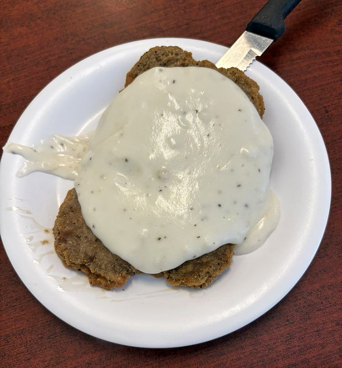 Behold the legendary country fried steak! That peppery white gravy cascading over crispy breading is what food dreams are made of.