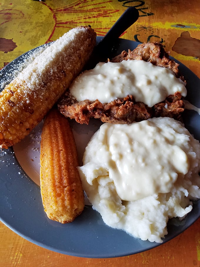Country fried steak that deserves its own ZIP code, smothered in pepper cream gravy alongside mashed potatoes and corn that's been dusted with parmesan fairy dust.