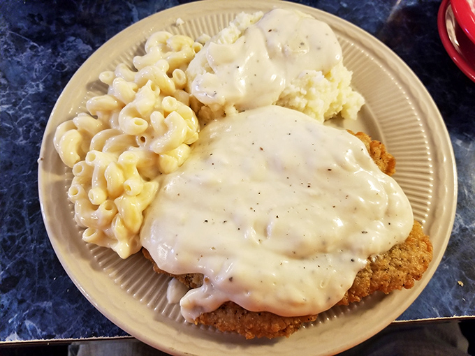 This country fried steak isn't just dinner—it's therapy on a plate, smothered in creamy gravy that could solve most of life's problems.