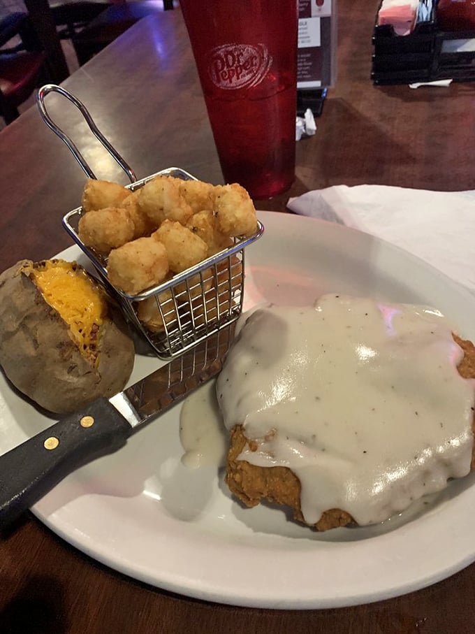 The country fried steak arrives like royalty under a crown of peppery gravy, with tater tots standing guard in their crispy golden armor.