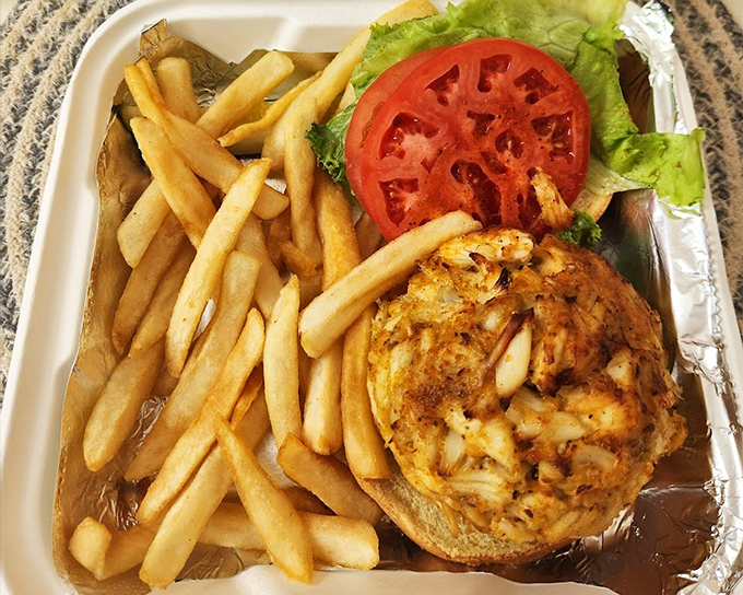 Behold the holy trinity of Maryland dining: golden-brown crab cake, crispy fries, and the obligatory slice of tomato that counts as your vegetable for the day.