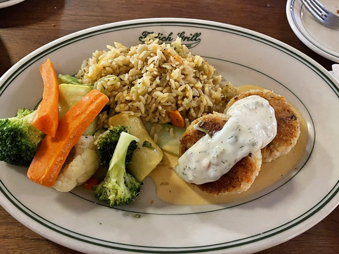 These golden-brown crab cakes aren't just food; they're edible history, served with seasonal vegetables and rice pilaf that complement without competing.