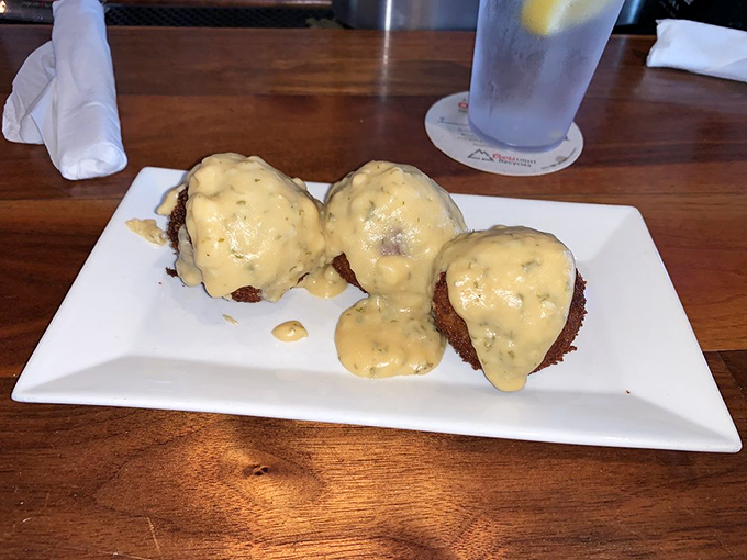 These crab cakes aren't just food; they're little golden islands of joy swimming in a sea of delectable sauce.