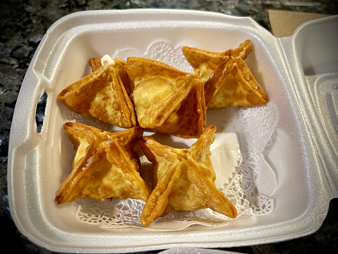 Golden-fried crab rangoon triangles that shatter with each bite, revealing a creamy interior that's worth every calorie.