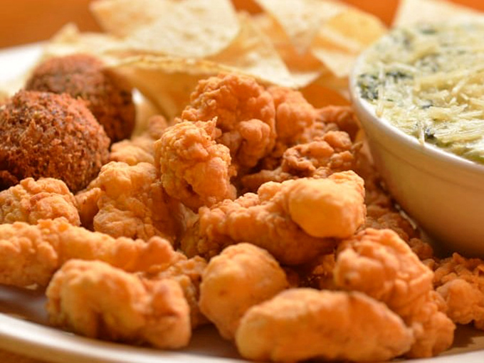 Golden-fried crawfish that crunch like nature's potato chips, paired with a dip that could make cardboard taste magnificent.