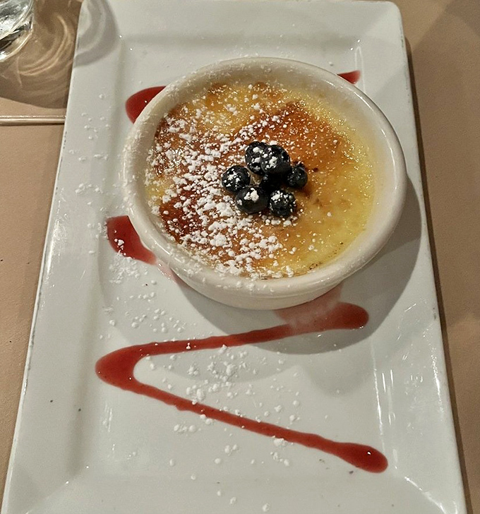 Cr&egrave;me br&ucirc;l&eacute;e that cracks like thin ice on a winter pond, topped with plump blueberries and a raspberry coulis signature.