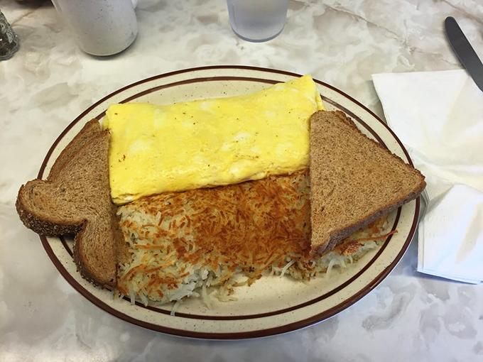 The Denver omelet arrives like a golden sunrise on a plate, flanked by perfectly crisped hashbrowns and toast standing at attention.
