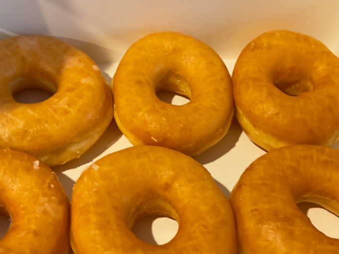 Golden-hued glazed donuts glisten with promise. These aren't just breakfast&mdash;they're edible sunshine that somehow makes Monday mornings bearable.