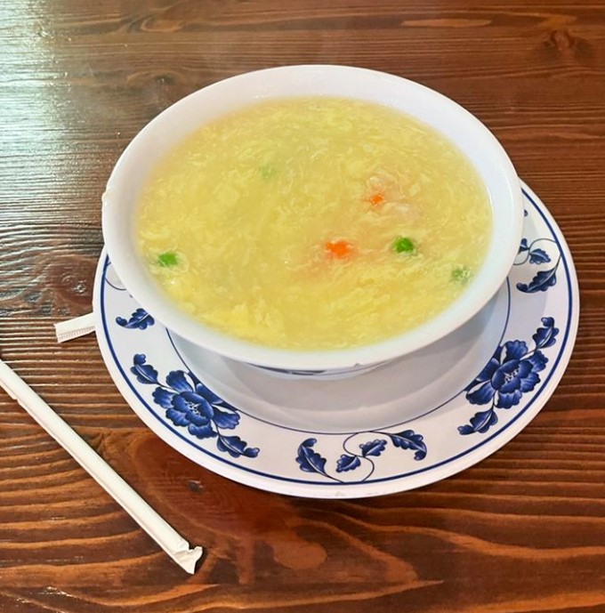 This isn't just egg flower soup&mdash;it's liquid comfort in a blue-rimmed bowl. Delicate egg wisps float like golden clouds in a broth that's clearer than your grandmother's advice.