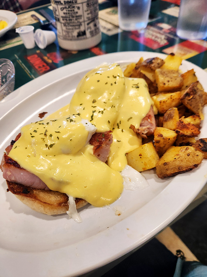 Eggs Benedict done right &ndash; golden hollandaise cascading over perfectly poached eggs and ham. Those home fries deserve their own fan club.