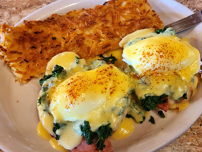 Behold the star attraction: Eggs Benedict with perfectly poached eggs, vibrant greens, and hash browns that deserve their own fan club.